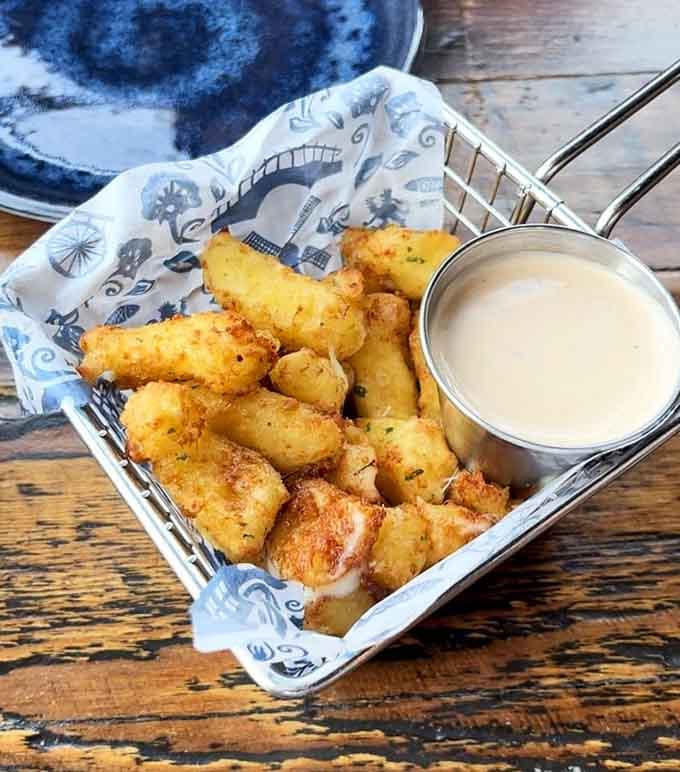 Golden cheese curds with dipping sauce prove Wisconsin and Belgium can absolutely be friends with benefits.
