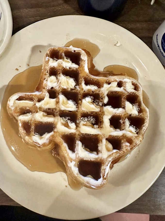 A Texas-shaped waffle dusted with powdered sugar and dripping with syrup, because everything really is bigger in Texas.