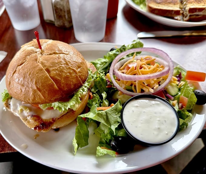 That burger sits on a bun like it owns the place, accompanied by a salad that's actually trying.
