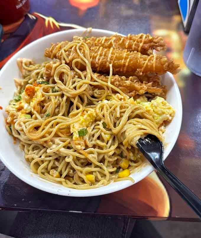 Crispy tempura shrimp perched on noodles like they're posing for their own action figure, absolutely picture-perfect and delicious.