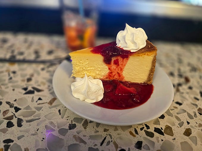 Creamy cheesecake with berry sauce, because every great performance deserves an equally impressive finale on your plate.