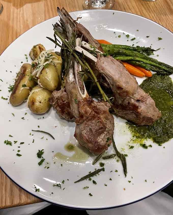 Lamb chops arranged like edible architecture, with fingerling potatoes and asparagus providing the perfect supporting cast members.