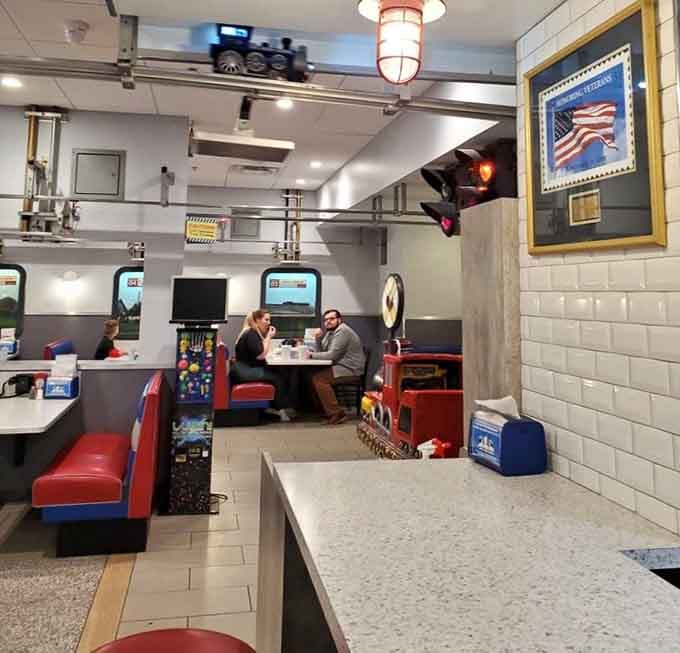 Families fill the booths while trains zip overhead, creating the kind of controlled chaos that somehow feels perfectly organized here.