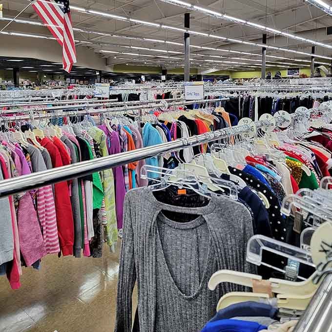 Clothing racks stretching endlessly under the American flag, because nothing says patriotism like saving money while shopping secondhand.