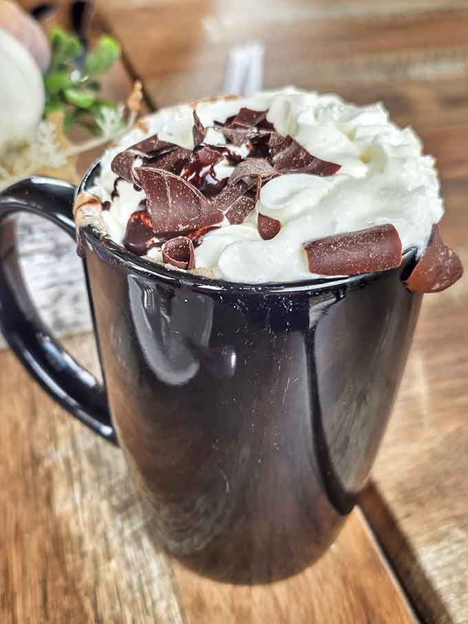 Hot chocolate topped with whipped cream and chocolate shavings, because sometimes you need dessert before your actual meal.