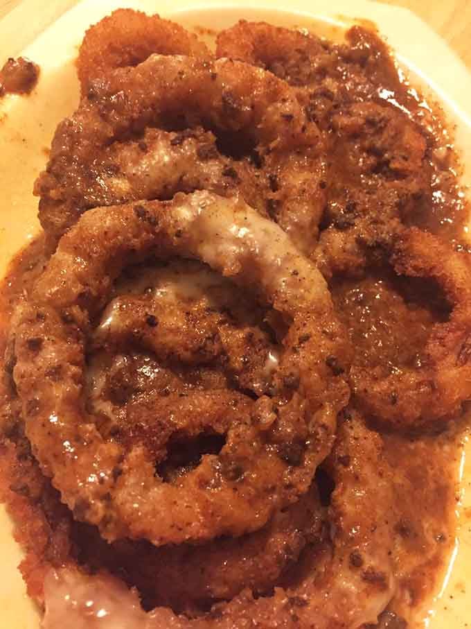 Golden onion rings with a crust so perfect they could moonlight as edible jewelry at fancy dinner parties.