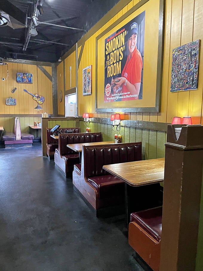 Booth seating that invites you to settle in for the long haul. The "Smokin' in the Boys Room" sign hints at the establishment's playful approach to serious barbecue.