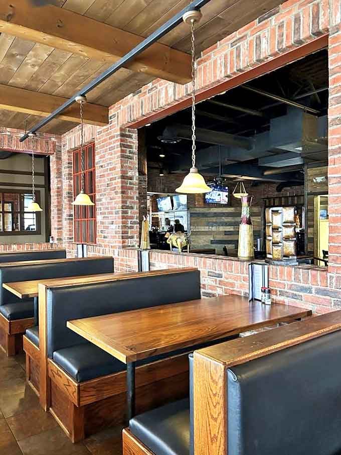 Wooden booths against exposed brick walls create intimate dining spaces where memories are made between bites of smoky perfection.