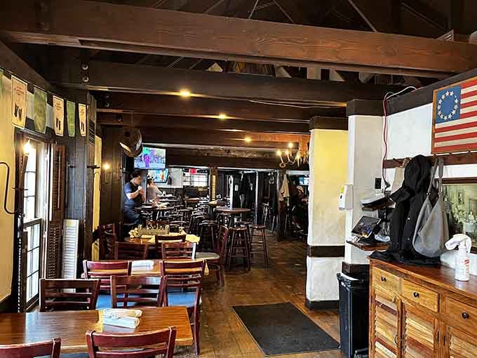 The tavern's rustic interior, with its 13-colony charm and modern sports on TV, bridges centuries of American gathering traditions.