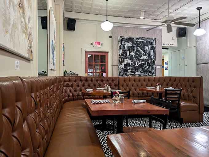 The tufted leather corner booth isn't just seating—it's a front-row ticket to the dinner theater that is Picasso Cafe.