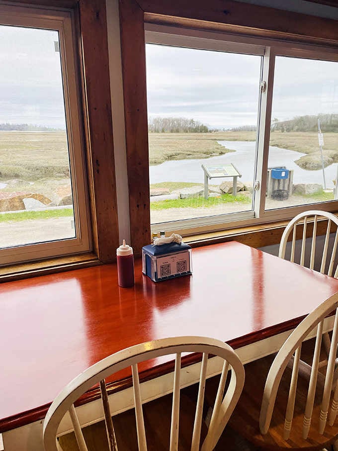 Ketchup bottles and napkin dispensers waiting patiently by the window, ready to support your seafood feast with quiet dignity.