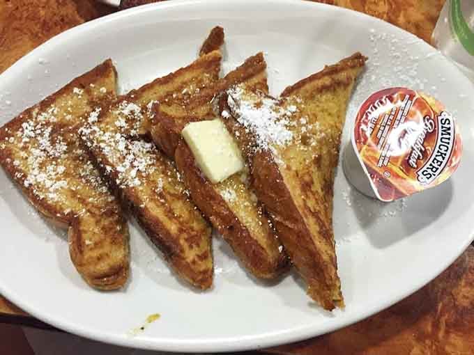 French toast dusted with powdered sugar and served with butter, proving simple pleasures never go out of style.