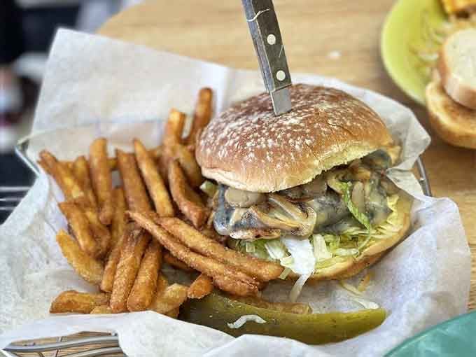 That burger arrives with a knife through its heart, holding together layers of mushrooms, cheese, and pure deliciousness.
