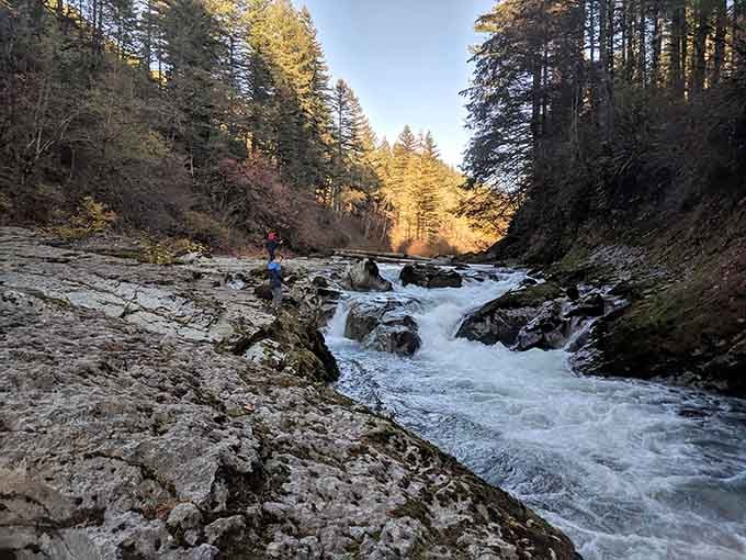 Golden hour light turns the riverside rocks into a natural amphitheater where families gather for impromptu picnics and storytelling.