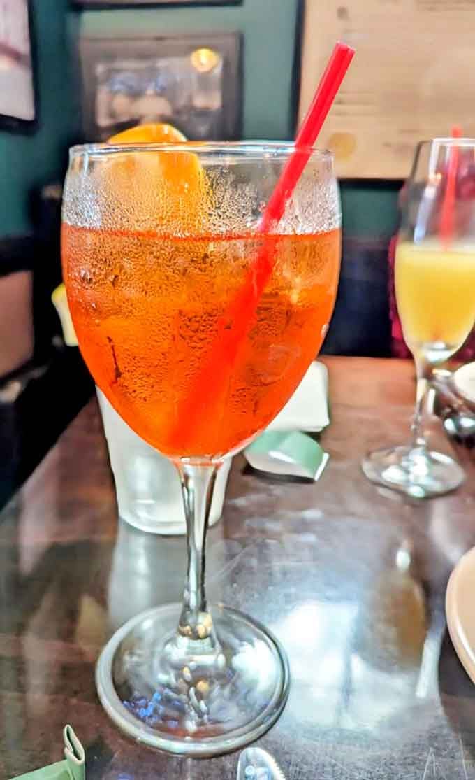 An Aperol Spritz catching the light, proving old bars can pour new classics with equal skill.