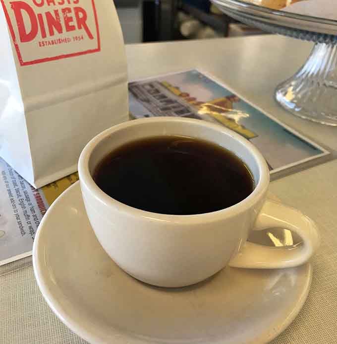 Fresh brewed coffee in a classic white cup, ready to fuel conversations and complement whatever deliciousness you've ordered.