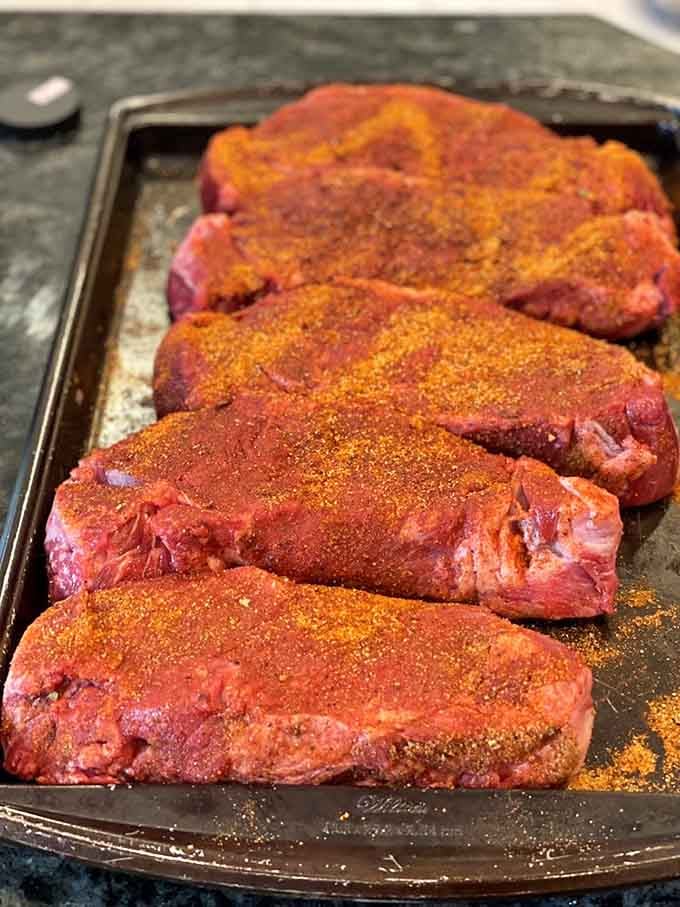 NY strip steaks seasoned and ready to transform your backyard grill into a five-star steakhouse experience tonight.
