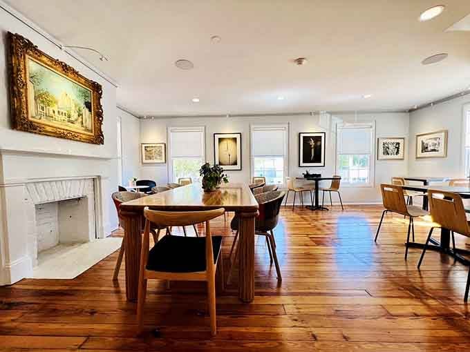 The upstairs dining room features elegant wooden tables and gallery-quality artwork in a bright, airy space perfect for celebrations.