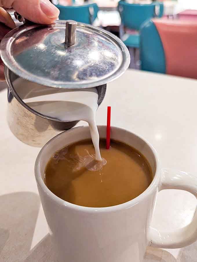 Fresh cream swirling into hot coffee like a morning ballet, the universal signal that everything's going to be alright.