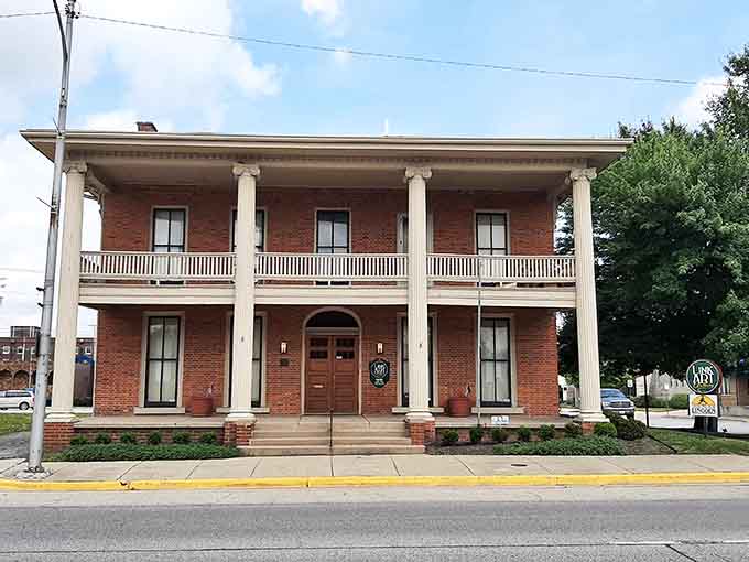 Classical columns frame a building that looks ready to host a garden party from 1850, minus the hoop skirts.