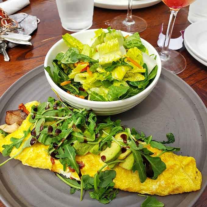 A fluffy omelet paired with fresh greens proves brunch at Penny Lane Pub takes both components seriously and deliciously.
