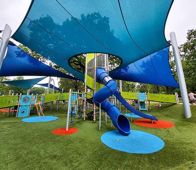 Playground paradise under blue shade sails invites young explorers to slide, climb, and burn off energy. Parents appreciate the thoughtful design almost as much as kids.