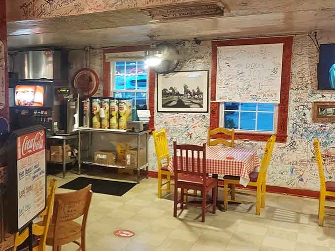 Checkered tablecloths and dollar-covered walls create an atmosphere that's pure barbecue joint authenticity at its finest.