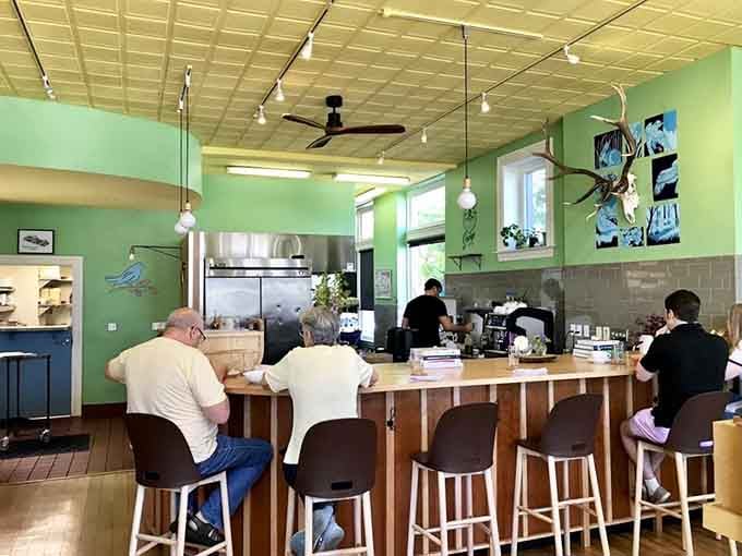 The bar area where you can watch breakfast magic happen while sipping coffee that actually tastes like coffee should.