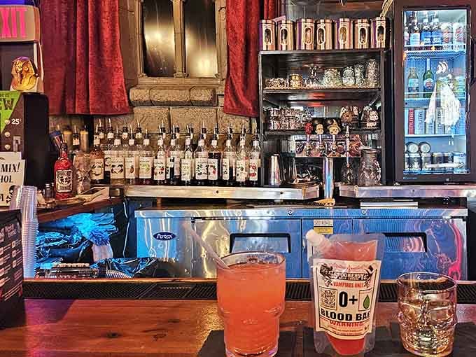 The bar gleams with bottles and possibilities, where mixologists craft drinks worthy of their theatrical surroundings.