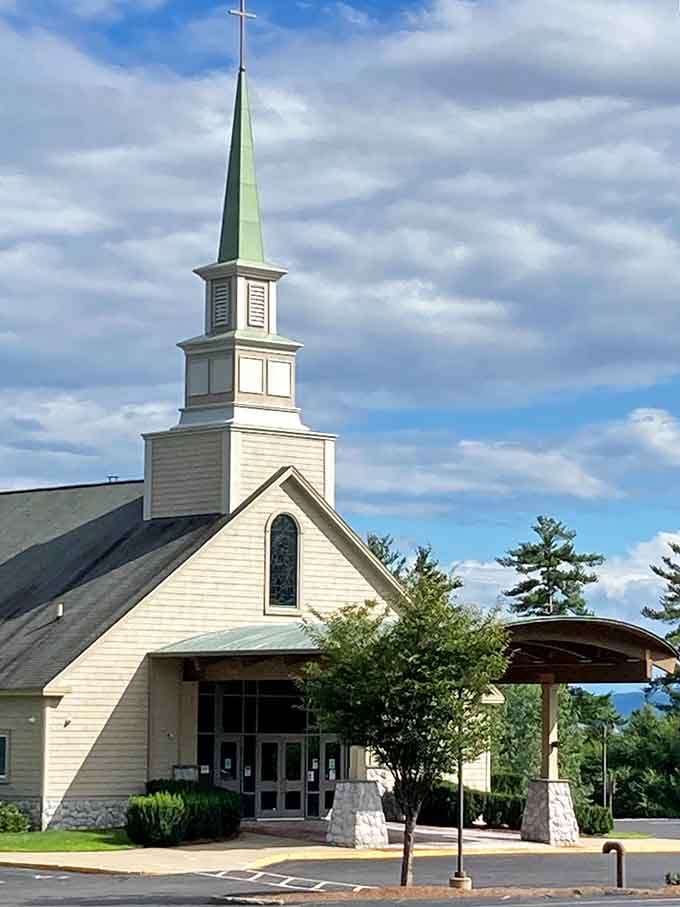St. Charles Borromeo's steeple reaches skyward, a spiritual landmark against New Hampshire's ever-changing cloud canvas.