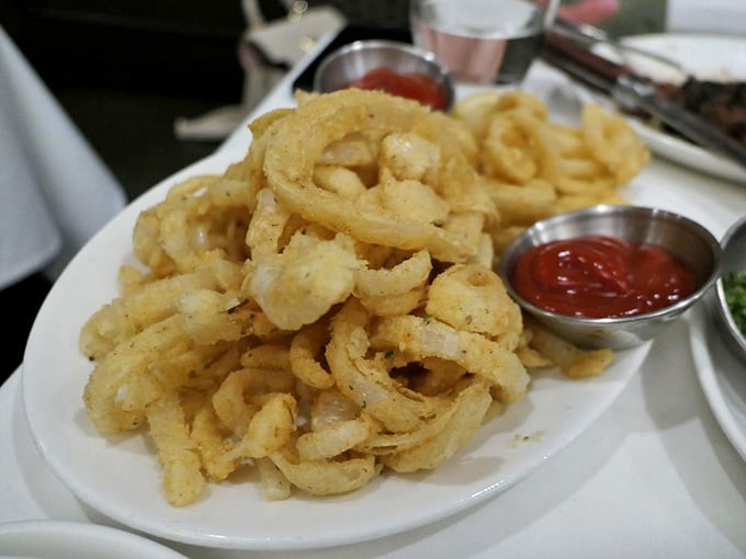 Golden, crispy onion rings piled high like edible architecture that disappears faster than you'd think physically possible.