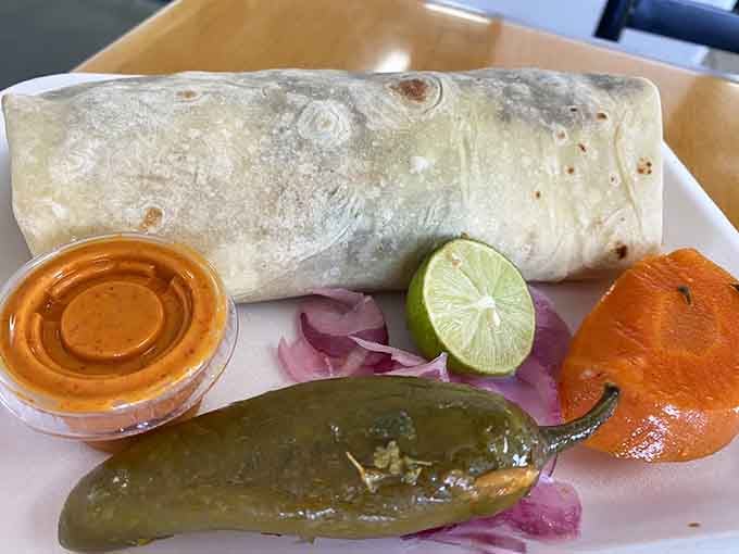 A burrito wrapped tight with pickled jalape&ntilde;os and carrots on the side. Portable perfection achieved in flour.