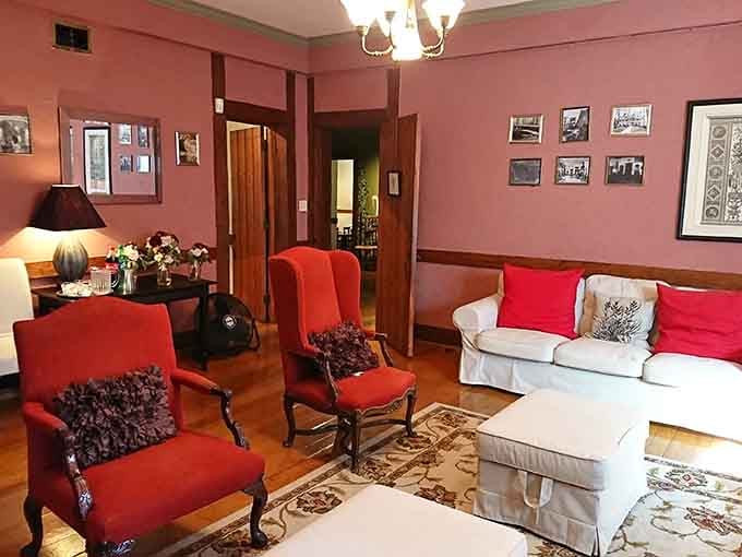 Red velvet chairs and warm lighting create cozy spaces that feel both historic and inviting.