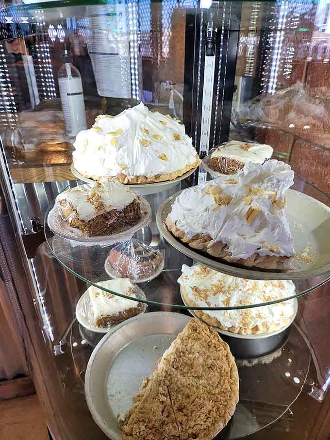 Homemade pies towering under glass like edible skyscrapers, sweet redemption after all those savagely named entrees you just ordered.