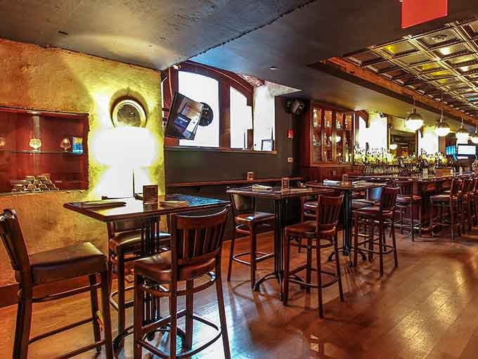 Tufted leather banquets and vintage mirrors line the walls, blending old-world charm with contemporary comfort beautifully.