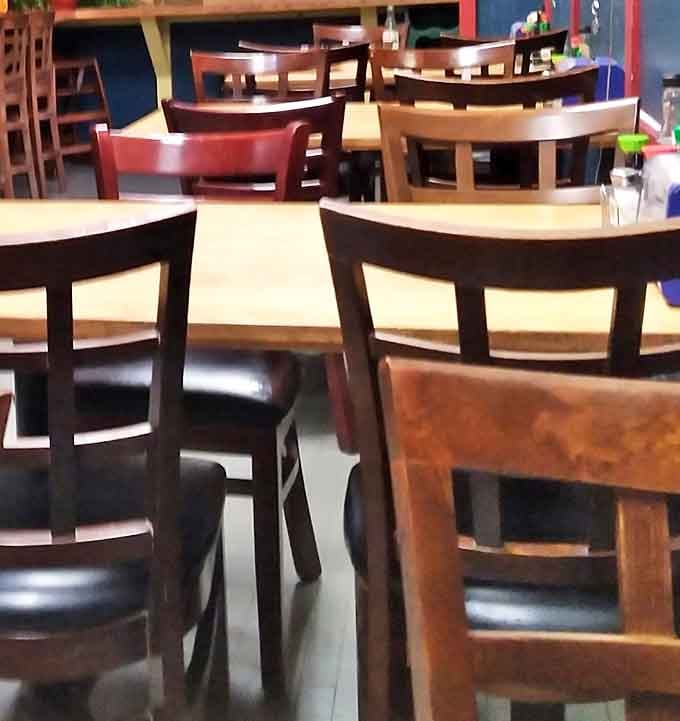 Simple wooden chairs and tables that say, "We're not fancy, but our seafood will make you forget what fancy even means."