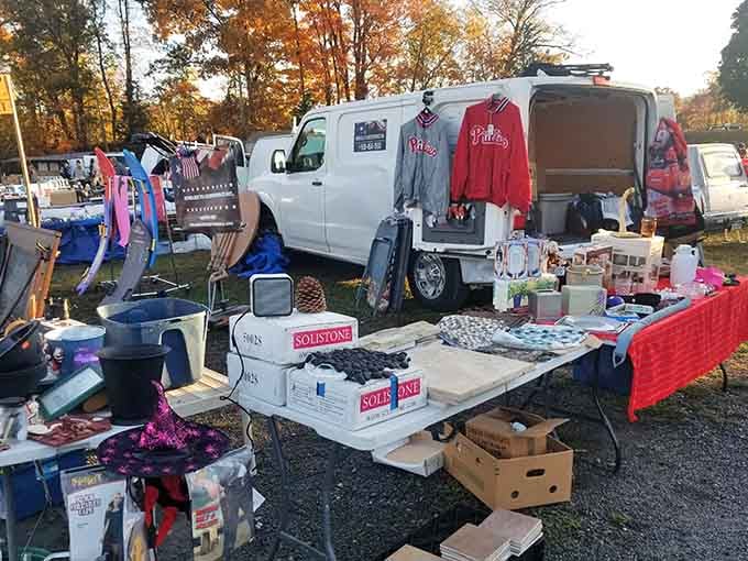Autumn colors peek through as vendors display Phillies gear and household items under golden afternoon light that photographers dream about.