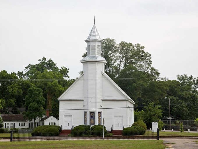 Camden's historic white church stands as a spiritual landmark, its pristine exterior and soaring steeple visible from throughout the small town.