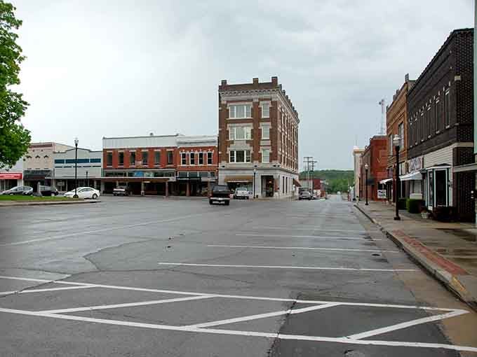 Rain-slicked streets reflect historic buildings in this quiet downtown where rush hour means waiting for one traffic light cycle.