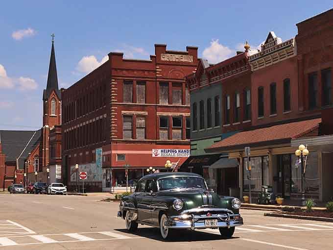 A classic car cruises past colorful storefronts, creating a scene so perfect it could be from "American Graffiti" or your fondest memories.