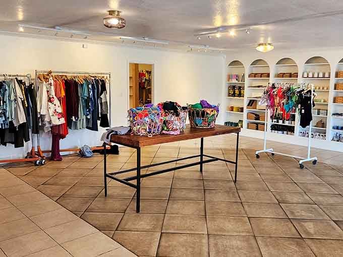 The bright, clean interior of Thrift on 46 showcases neatly organized clothing racks and colorful accessories in baskets, creating a boutique-like atmosphere.