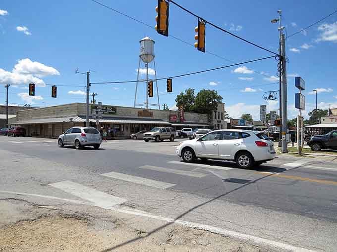 The intersection bustles with local traffic beneath that iconic water tower, proving small towns still have plenty of life.
