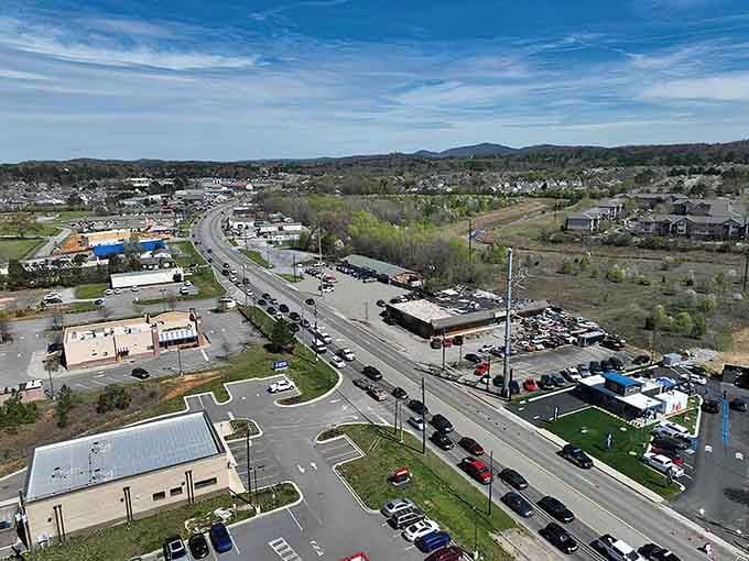 The highway hums with everyday commerce while green hills promise escape is always just minutes away from routine.