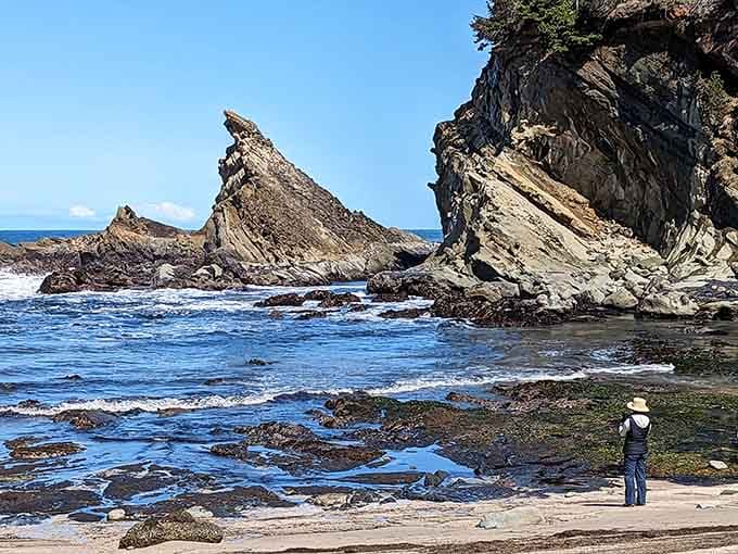 Tilted rock layers tell geological stories millions of years old while a lone explorer contemplates time's passage.