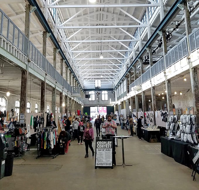 Soaring industrial architecture transforms into a cathedral of commerce where vintage fashion meets modern creativity under magnificent steel beams.