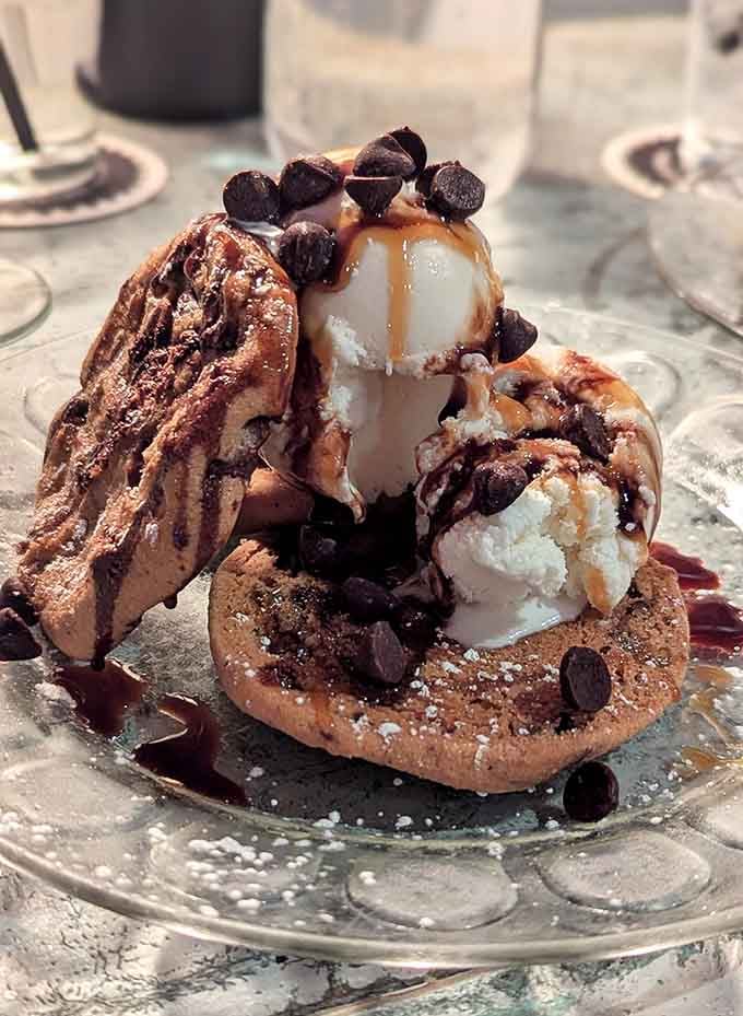 Dessert arrives as a chocolate-drizzled tower of waffles and ice cream, because subtlety left the building.
