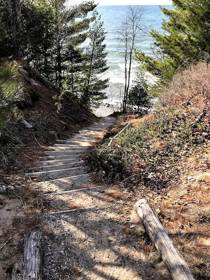 Wooden stairs descending to Lake Superior's shore where the water is cold enough to make you reconsider everything.