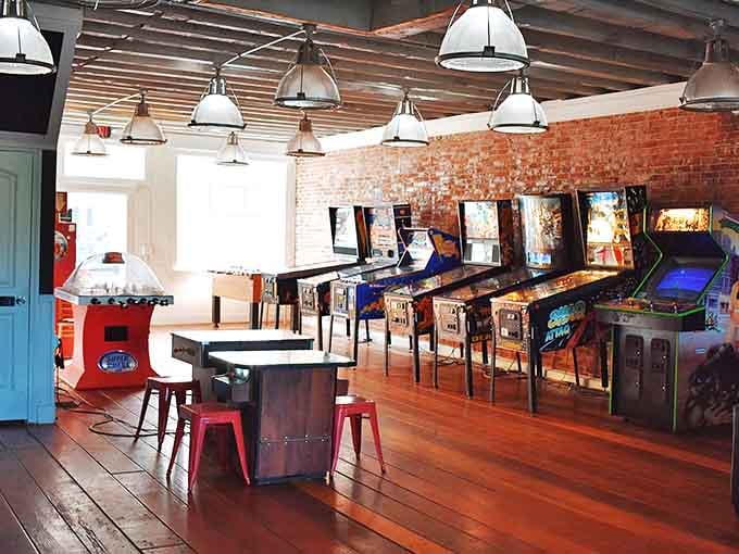 Vintage pinball machines line exposed brick walls, proving that entertainment doesn't need software updates to deliver genuine joy.