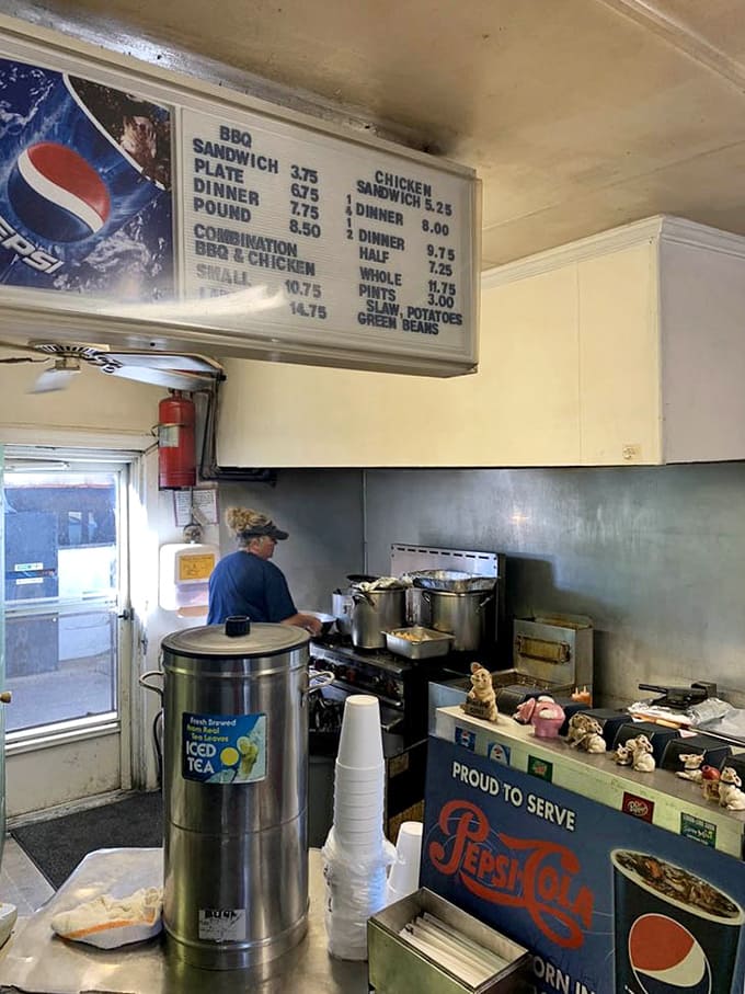 Behind-the-scenes glimpse of the kitchen where the magic happens, steam rising and pork transforming into pure Carolina gold.