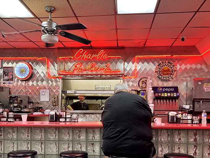 Counter seating with a view of the kitchen action, where neon signs and nostalgia create the perfect dining backdrop.